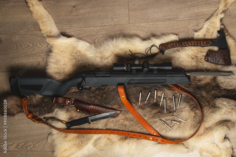 The scout's rifle lies on the skin of a wolf, next to the hunter's ...