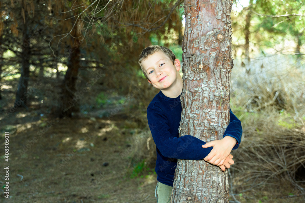 Child hugging a tree in a dark forest, taking care of the planet. Stock ...