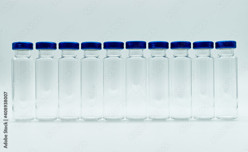 Row of transparent glass medical vials for injection with blue sealed ...