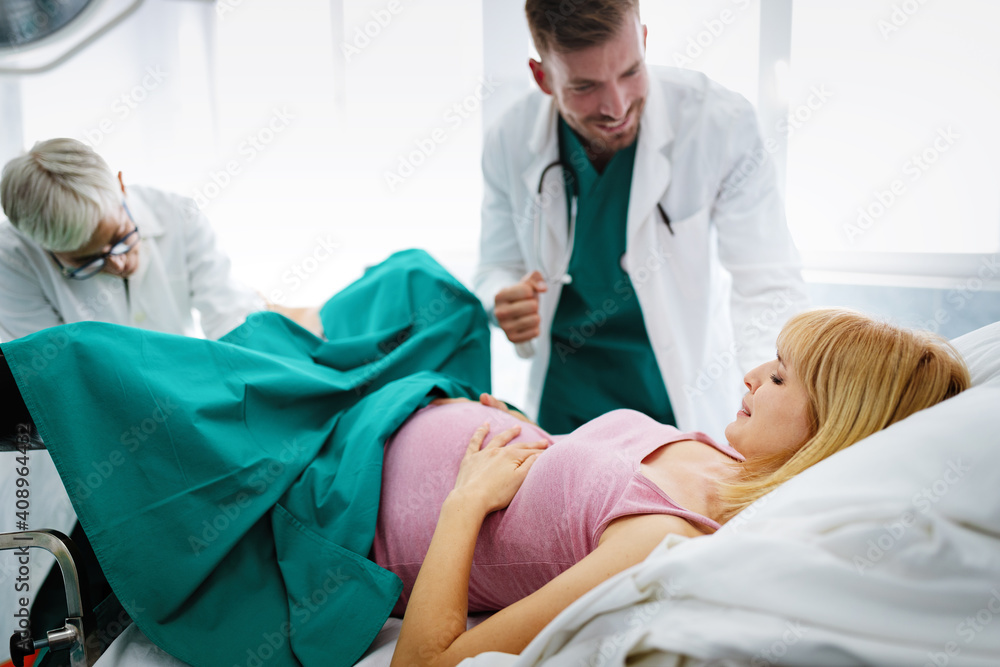 Woman giving birth in hospital with medical team Stock Photo | Adobe Stock