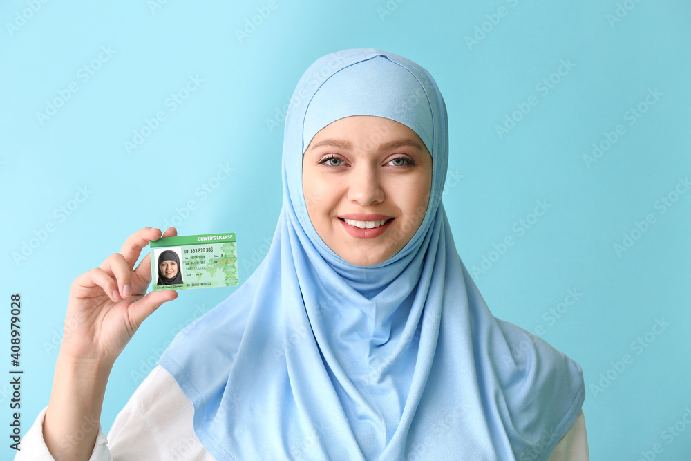 Happy Muslim woman with driving license on color background Stock Photo ...