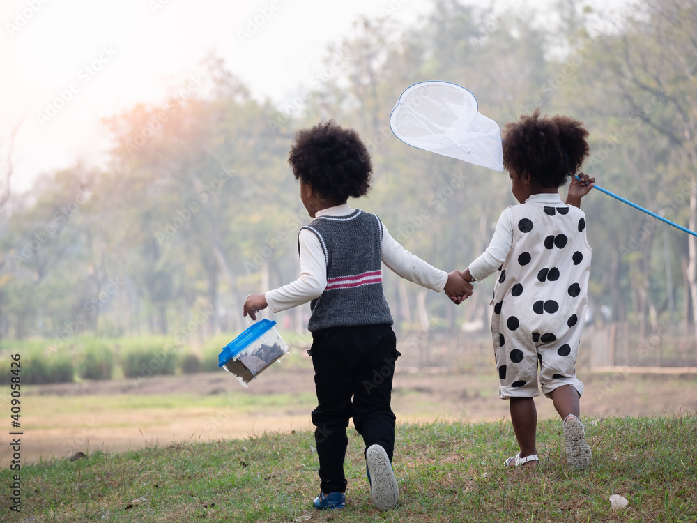 African American boys and girls catch insects in the forest on ...