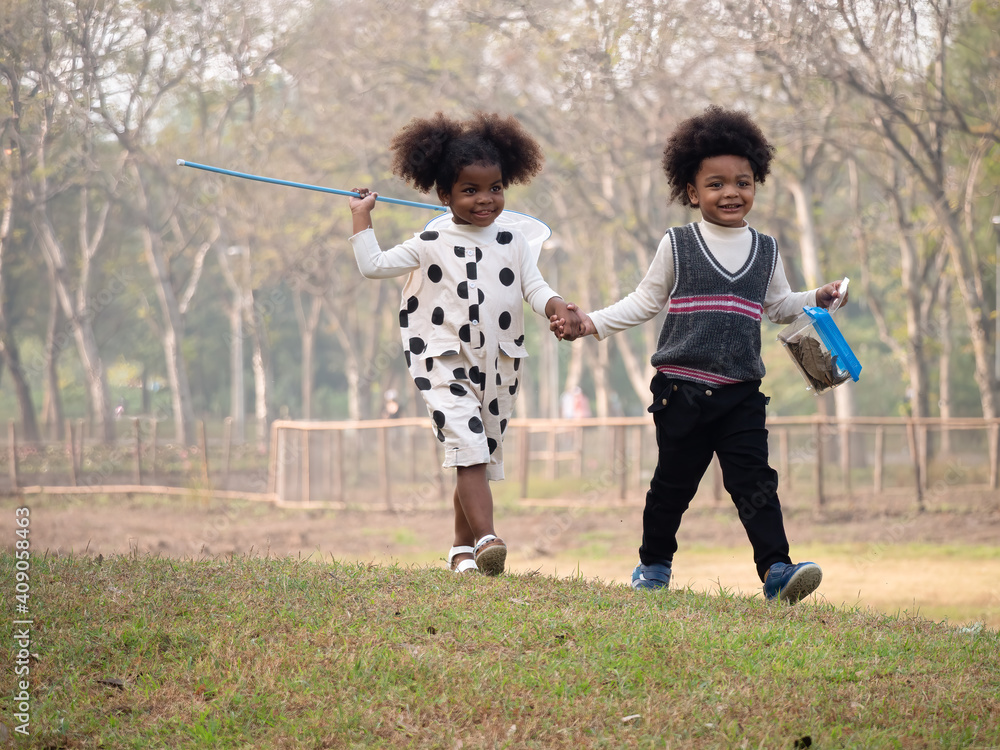 African American boys and girls catch insects in the forest on ...