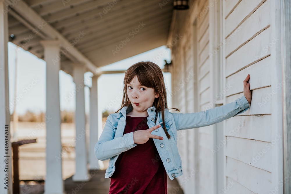 Silly young girl making a funny face and giving peace sign Stock Photo ...