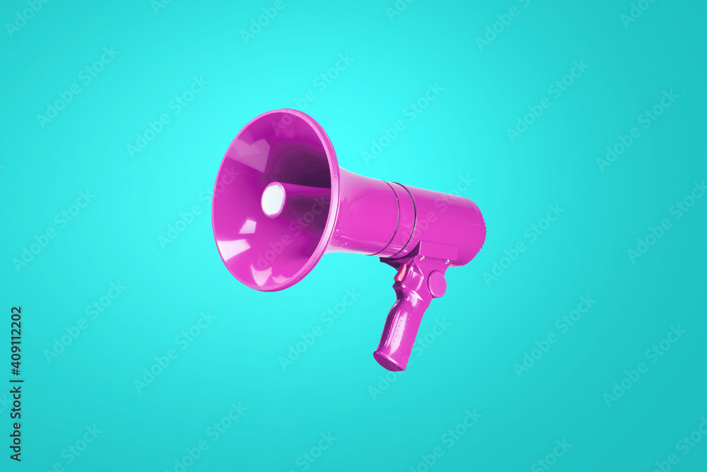 Beautiful colored pink megaphone on a cold blue background. A ...