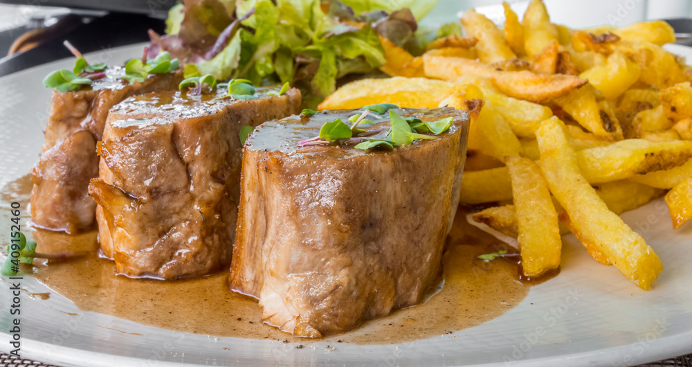 Filet mignon de porc, frites, salade Stock Photo | Adobe Stock