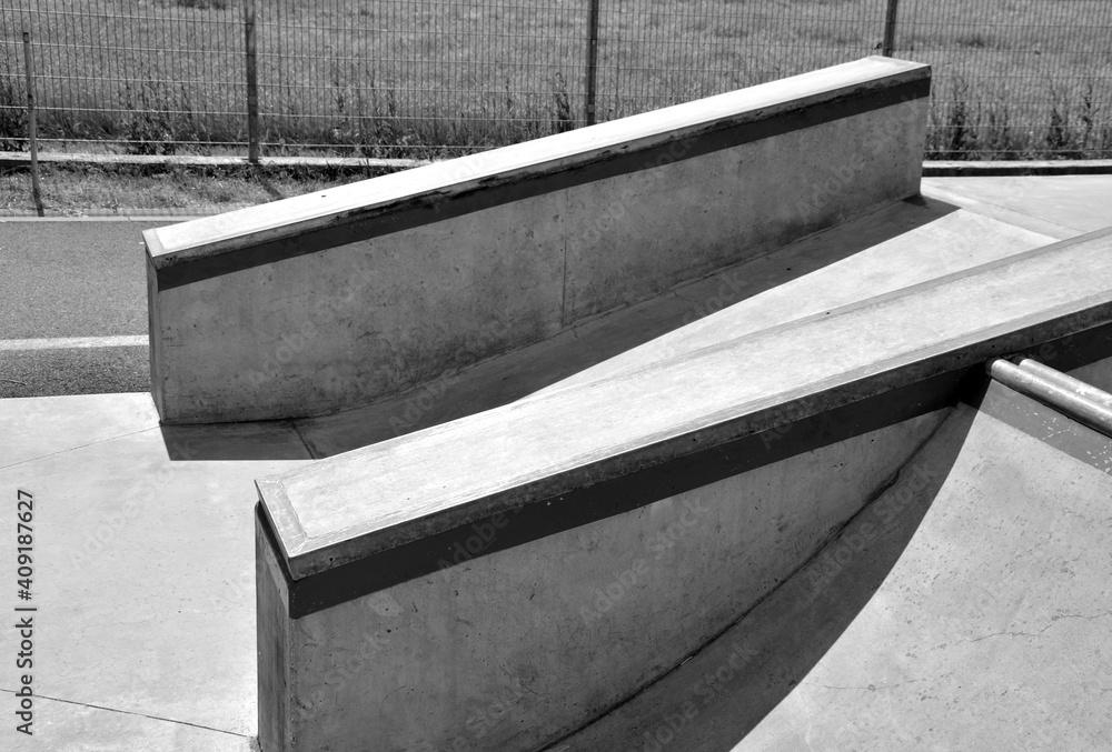 concrete skateboard playground in a fenced area outside the city ...