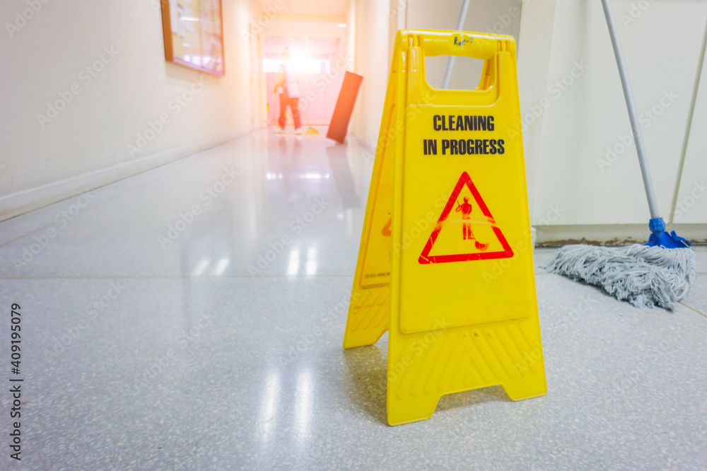caution wet floor warning sign with blurred worker mopping floor Stock ...