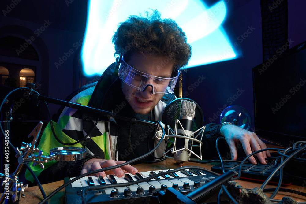Angry caucasian composer looks at camera and plays music using midi ...