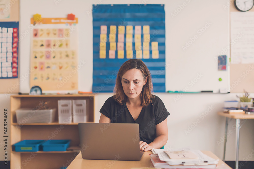 Elementary school teacher working on her laptop. Stock Photo | Adobe Stock