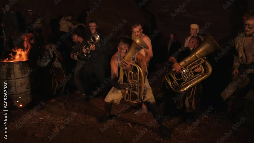 Crazy orchestra playing. Funny musicians play underground in a cave at ...