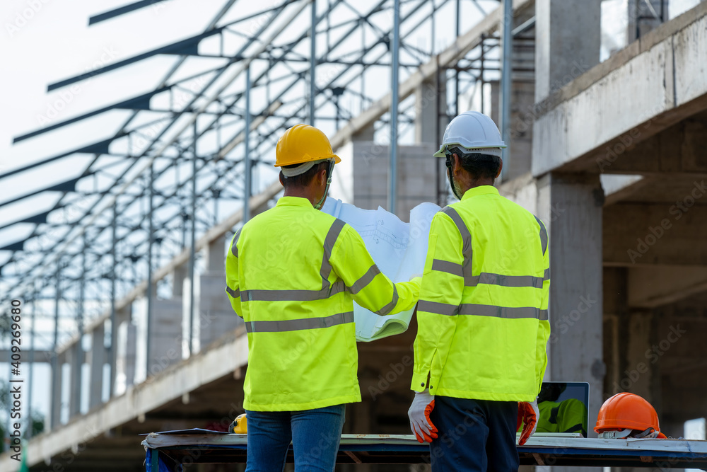 Architect working with blueprints on a building construction site ...