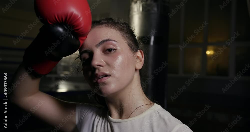 Smiling young woman boxer wiping her brow. Smiling young woman boxer ...
