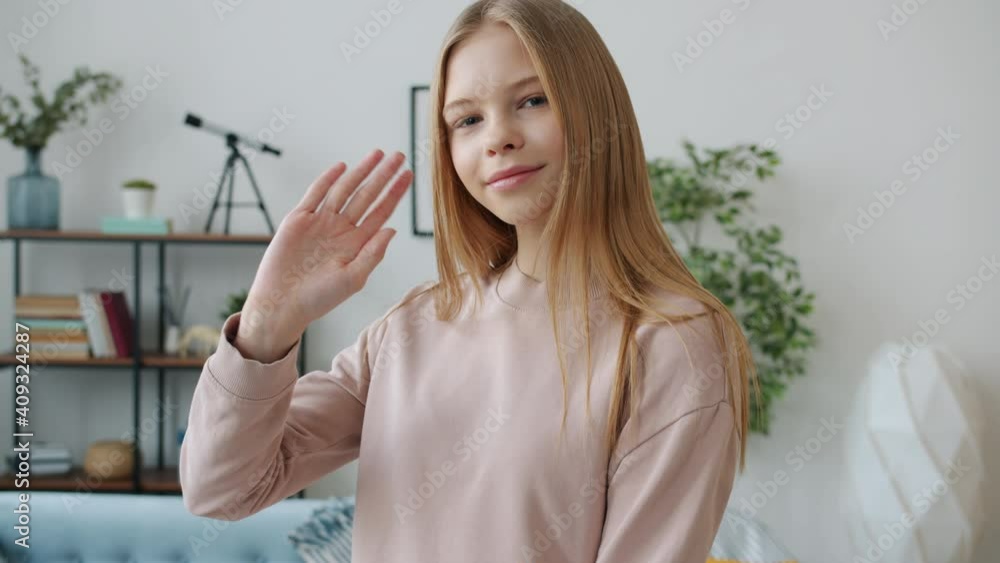 Slow motion portrait of happy teen girl waving hand smiling looking at ...
