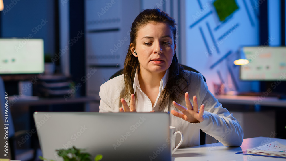 Business woman using wireless headphone duing video conference working ...