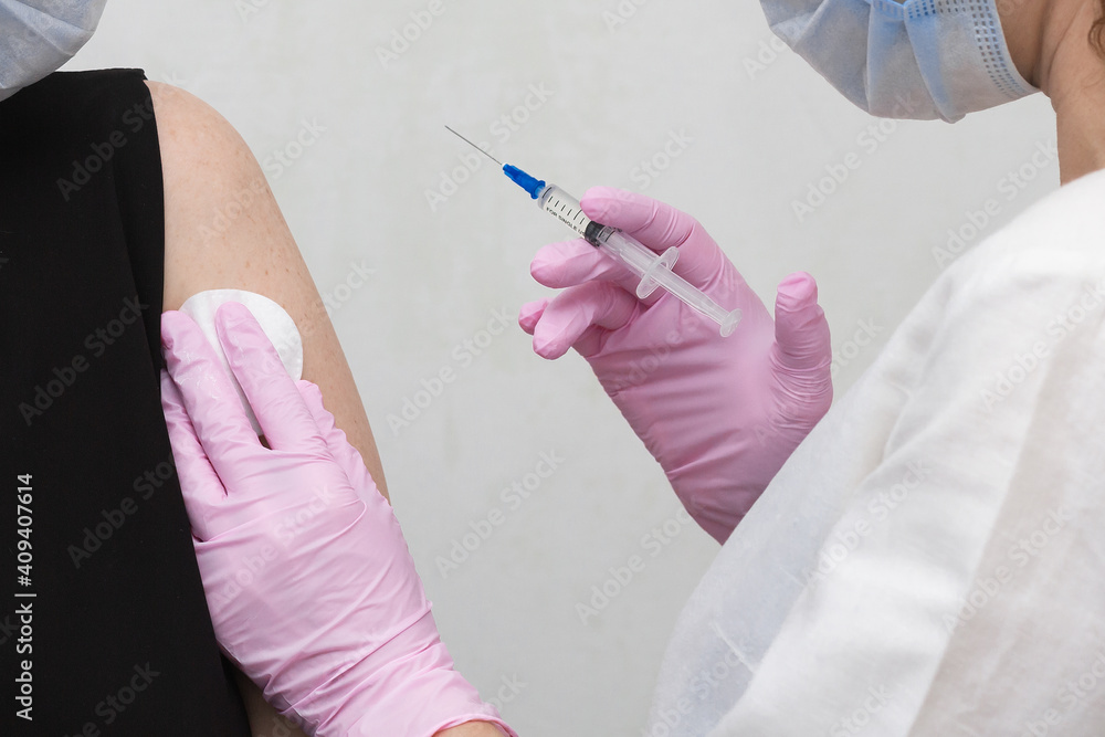Covid-19 vaccination. A female patient receives a coronavirus ...