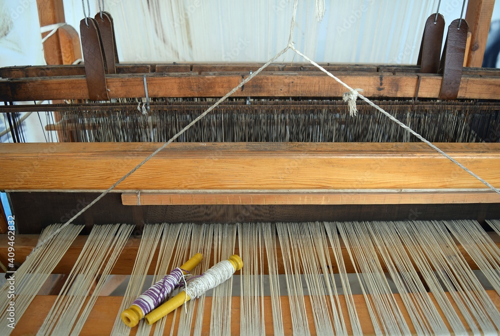 The machine is a hand-made wooden loom with threads for working on the ...