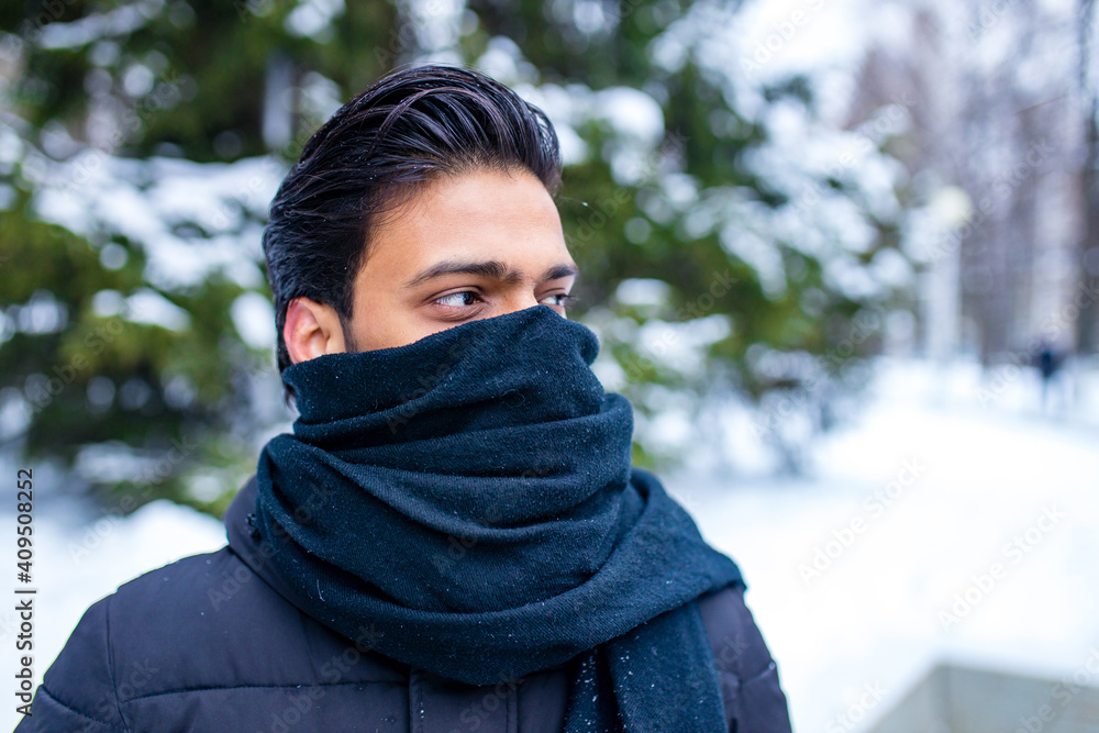 indian man enjoying snowflakes falling from upwards in forest wrapped ...
