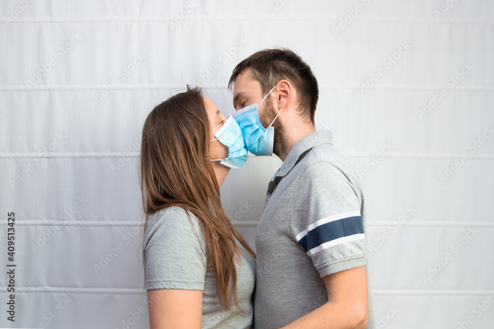 Loving couple wearing a protective face mask and staring at each other ...