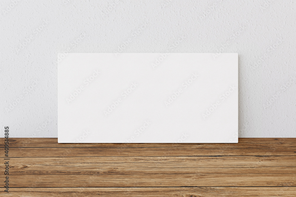 Rectangular blank canvas of 2x1 proportions on wooden surface and white ...