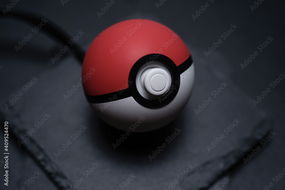 KUALA LUMPUR, MALAYSIA - JUNE 13TH, 2019 : A Poké Ball Plus on a black ...