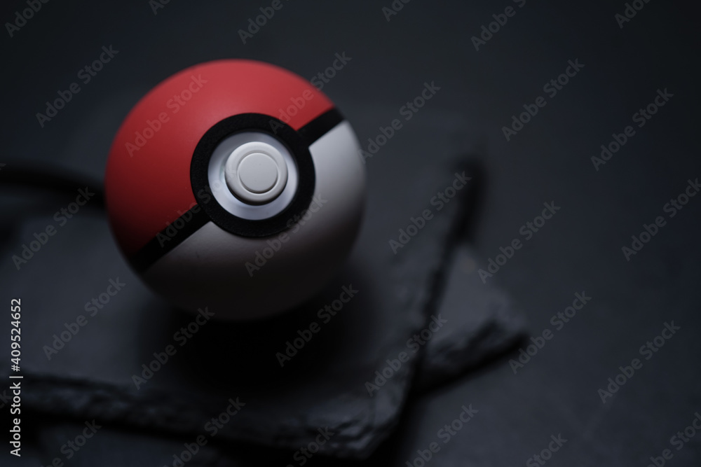 KUALA LUMPUR, MALAYSIA - JUNE 13TH, 2019 : A Poké Ball Plus on a black ...