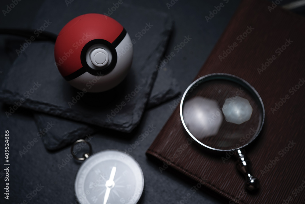 KUALA LUMPUR, MALAYSIA - JUNE 13TH, 2019 : A Poké Ball Plus on a black ...