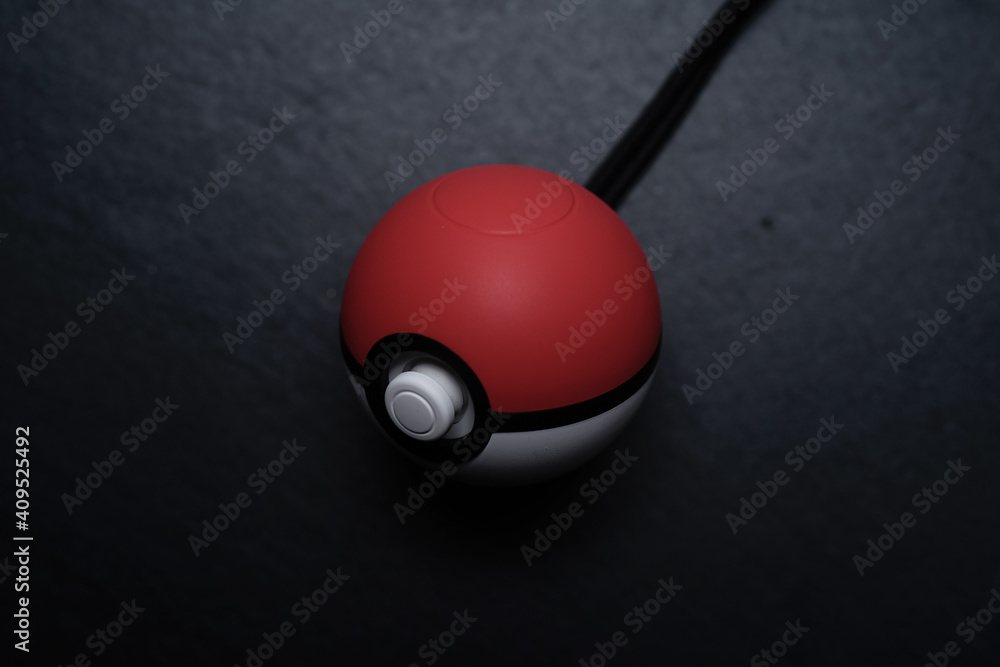 KUALA LUMPUR, MALAYSIA - JUNE 13TH, 2019 : A Poké Ball Plus on a black ...