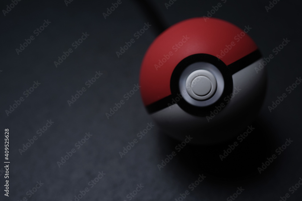 KUALA LUMPUR, MALAYSIA - JUNE 13TH, 2019 : A Poké Ball Plus on a black ...