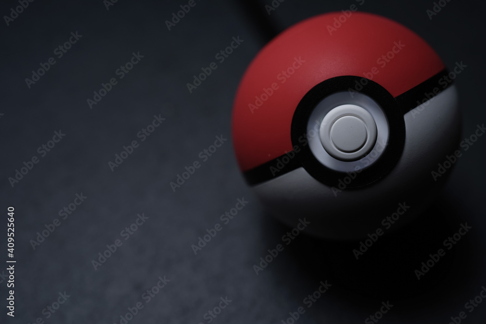 KUALA LUMPUR, MALAYSIA - JUNE 13TH, 2019 : A Poké Ball Plus on a black ...