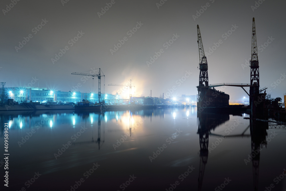 Cargo port terminal and river at night. Ship's, cranes, warehouse ...