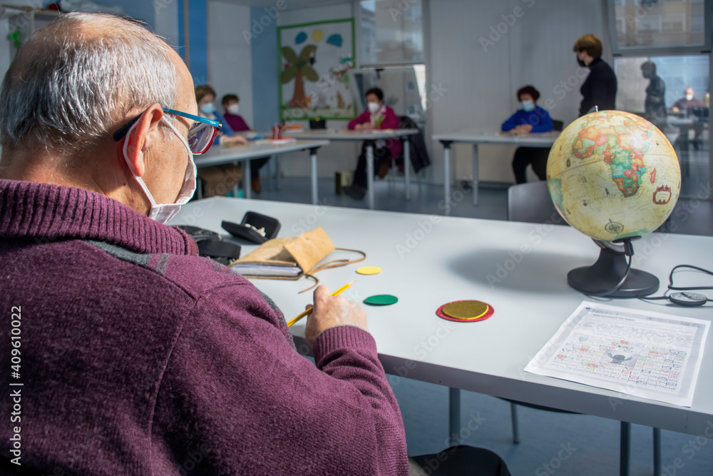 Retired man attending class in community center. Wearing face mask ...
