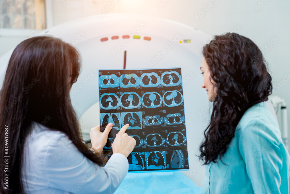 Radiologist with a female patient examining a CT scan Stock Photo ...
