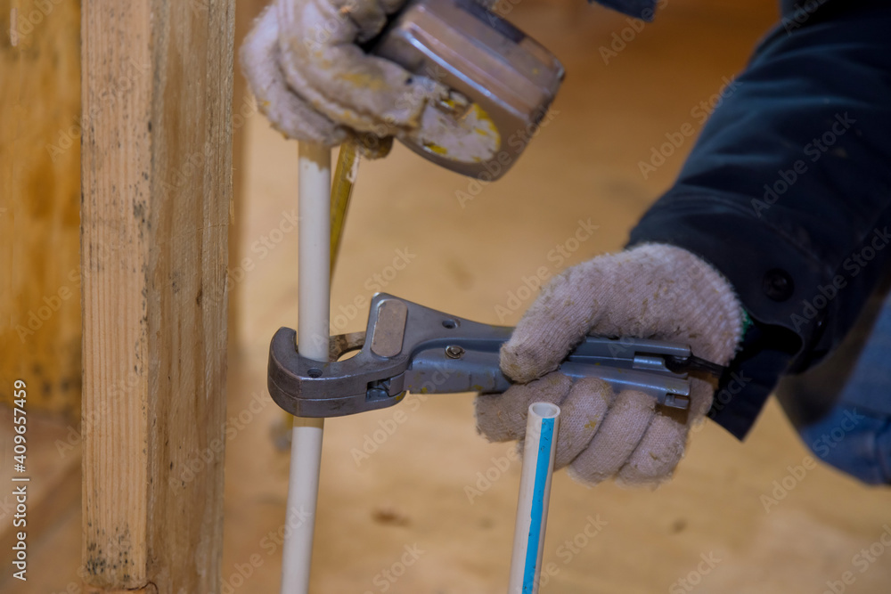 Maintenance plumber man hand using pvc pipe cutter for cut the water ...