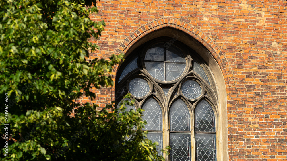 Street view on church's red brick wall with medieval, gothic stained ...