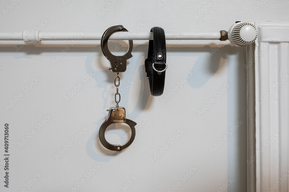 Handcuffs on the radiator. Police handcuffs and collar. Stock Photo ...