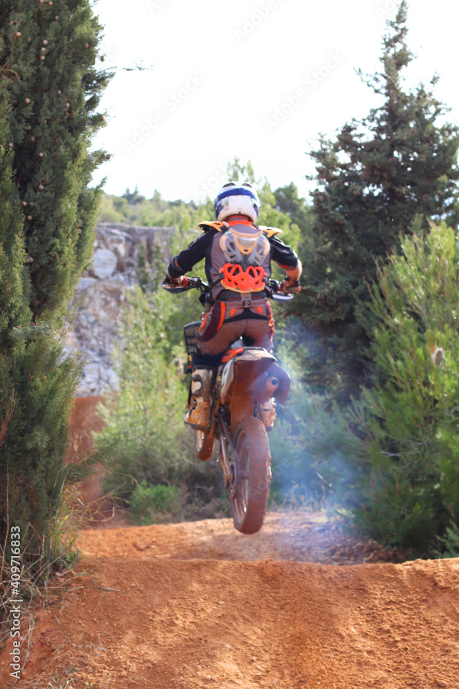 Professional dirt bike motocross rider performing stunts and flying ...