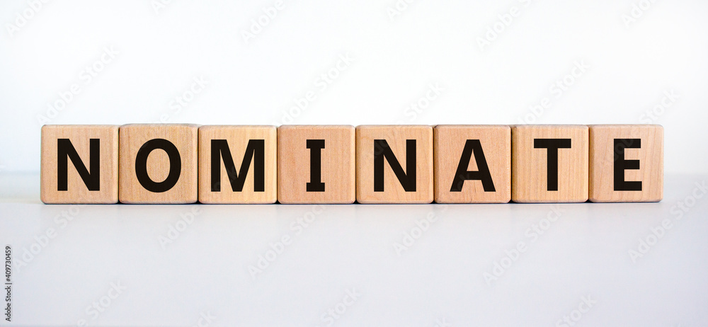 Nominate symbol. Wooden cubes with word 'nominate'. Beautiful white ...