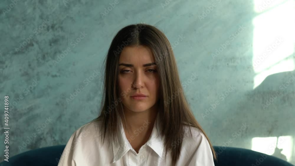 Displeased female in white shirt looking at camera during reception at ...