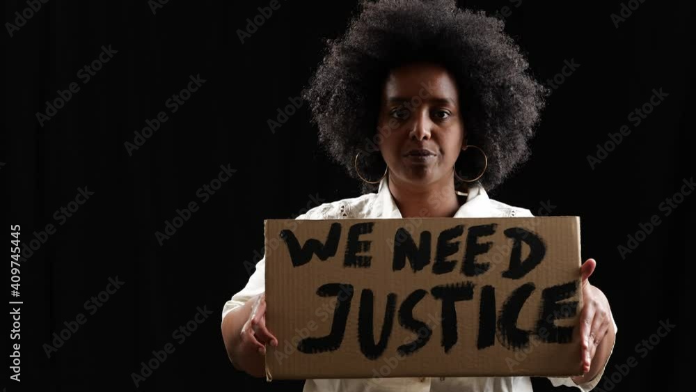 [4k] serious black woman saying we need justice raising cardbord sign ...