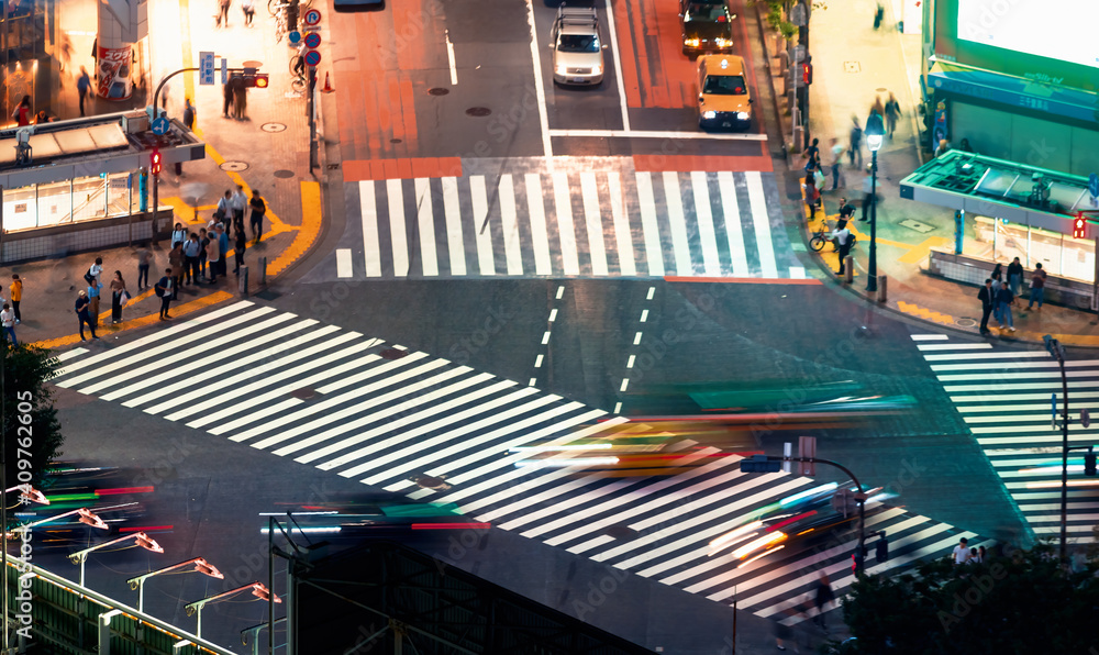 People and traffic cross the famous scramble intersection in Shibuya ...