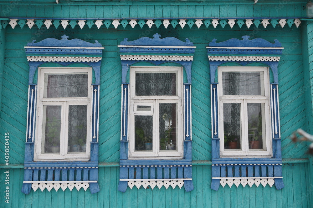 Ornamental windows with carved frames on vintage wooden rural house in ...