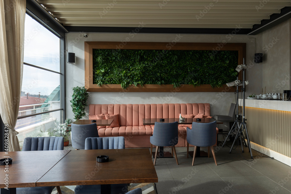 Interior of an empty restaurant with a view and a grass wall decoration ...