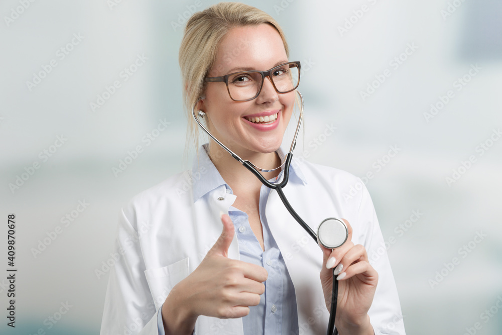 Portrait of a female family doctor in doctor's overall with stethoscope ...