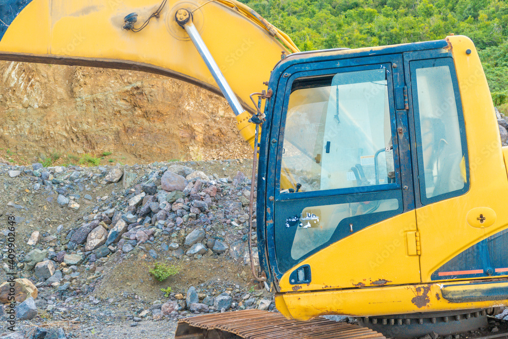 Bulldozer equip with drill, breaking down a hill landscape for homes ...
