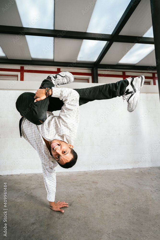 Full body of energetic young man doing acrobatic handstand while ...