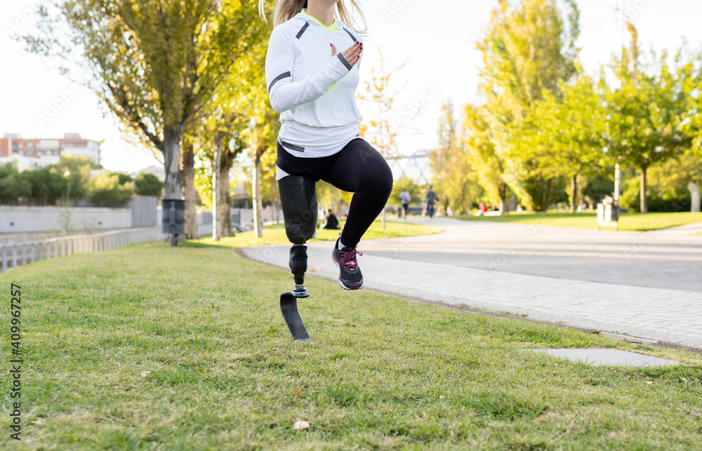Side view of Paralympic female runner with artificial leg doing ...