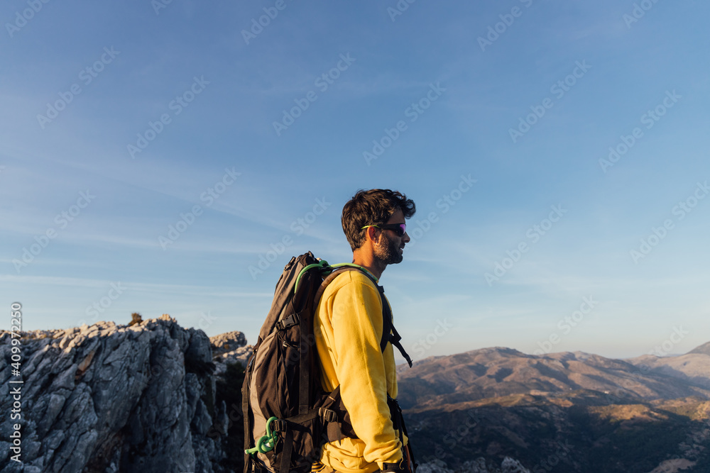 Side view of lonely unrecognizable male explorer with backpack standing ...