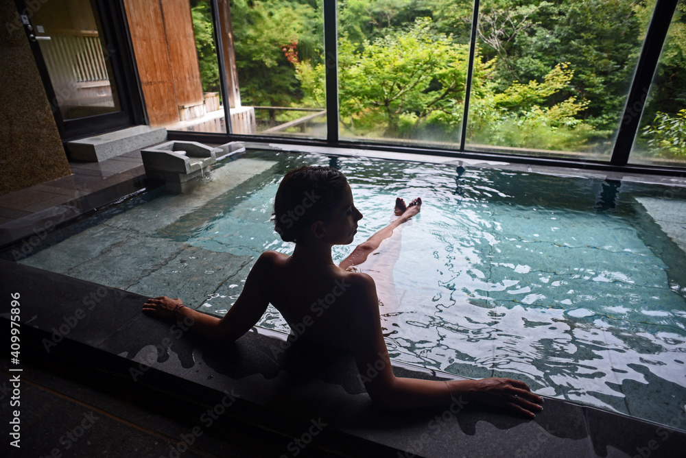 Silhouette of young caucasian woman enjoying.a relaxing thermal waters ...