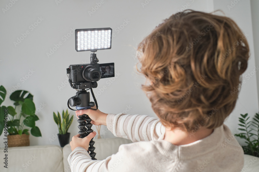 Back view of faceless boy making video in his house for his channel ...